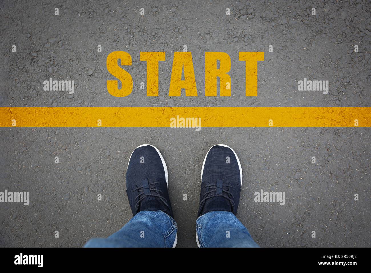 New beginnings. Man standing near word Start on asphalt, top view Stock ...