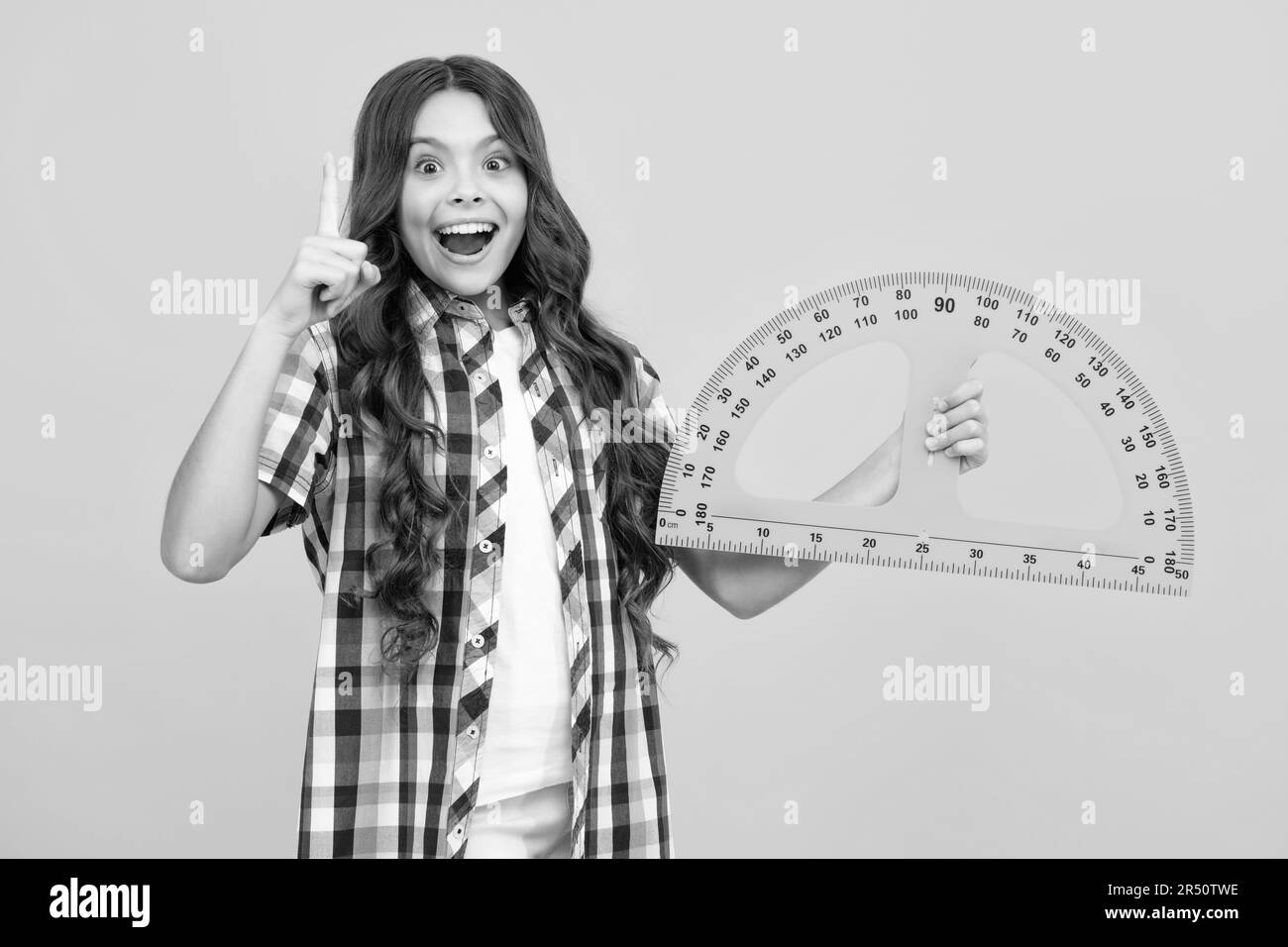 Amazed teen girl. Schoolgirl in school uniform hold mathematics measure ...