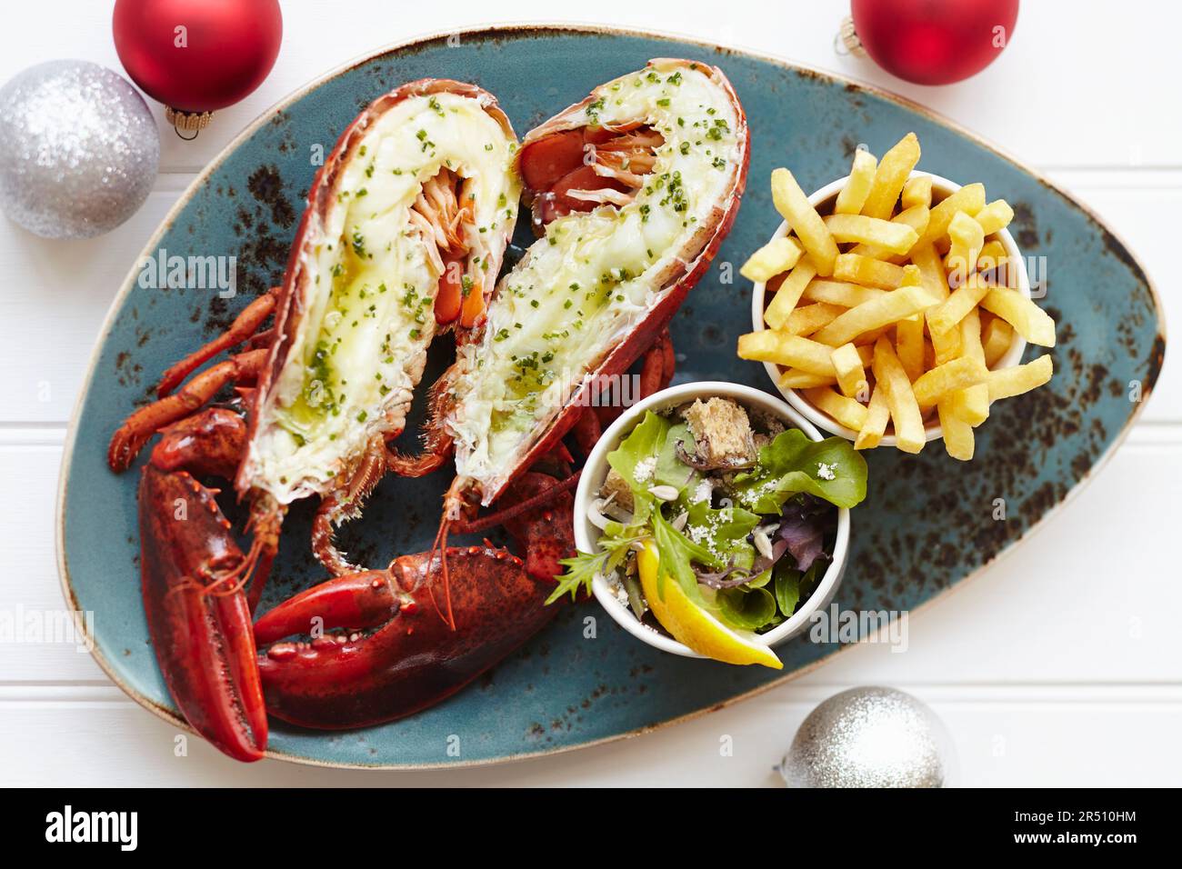 Cooked lobster split into two, in shell with garlic and herb butter ...