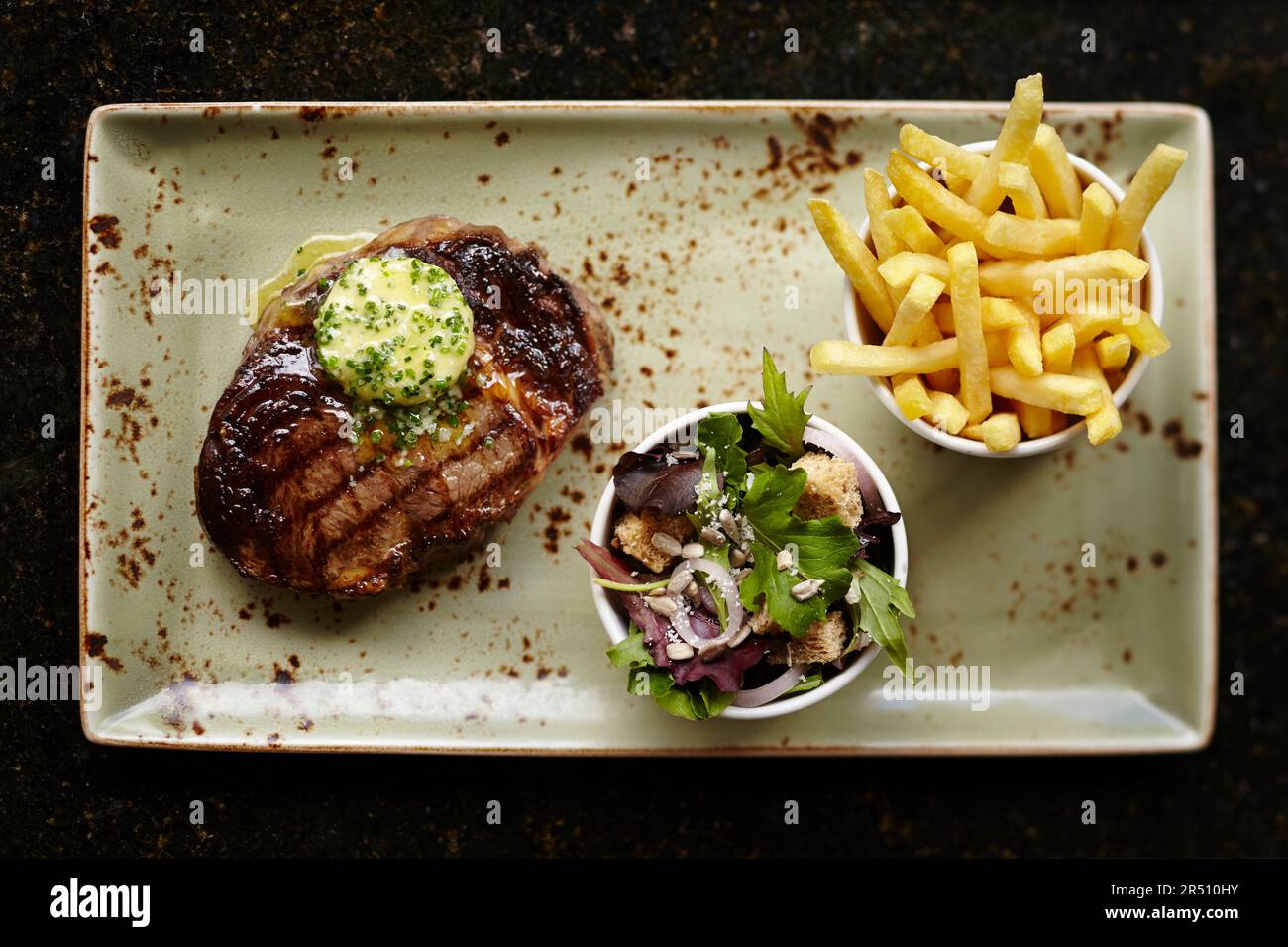 Cooked juicy steak with melting garlic and herb butter, cripsy fries ...