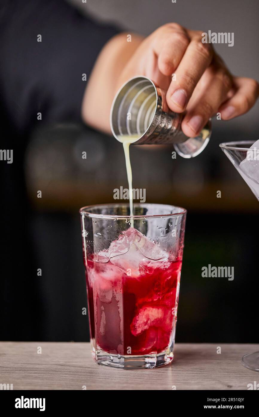 Making Cosmopolitan cocktail, pouring lime juice in a glass Stock Photo ...