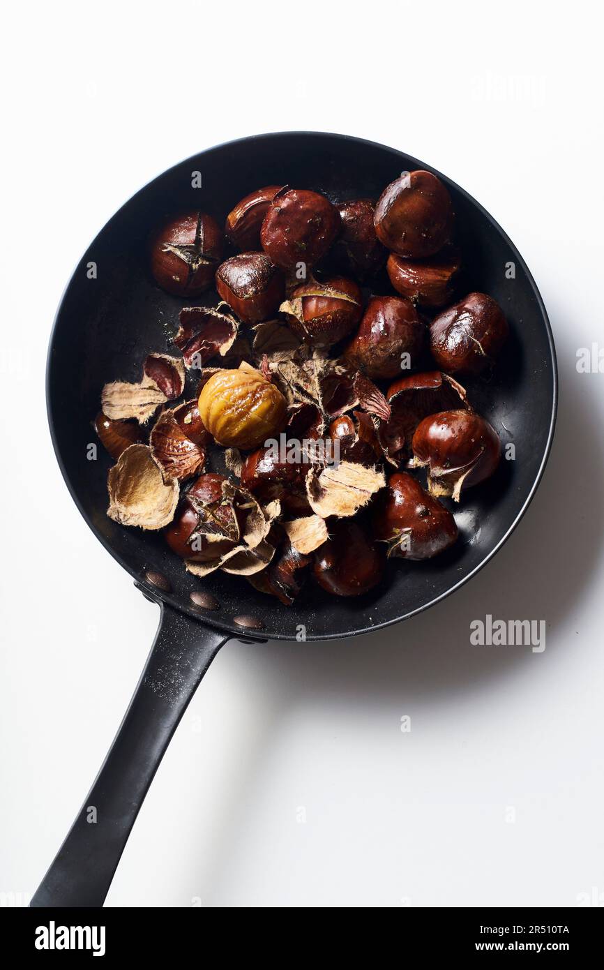Roasted chestnuts in a pan Stock Photo - Alamy