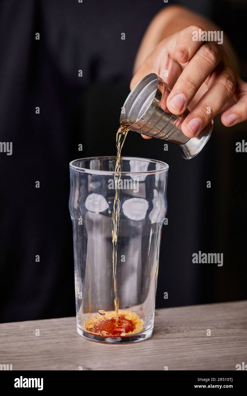 Making Old Fashioned cocktail, pouring bitter liquor in a glass Stock ...
