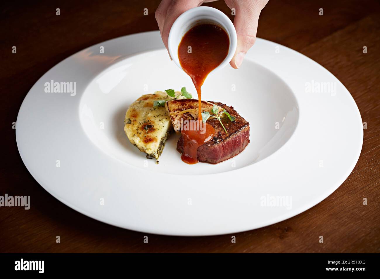 Pouring sauce on steak Stock Photo - Alamy