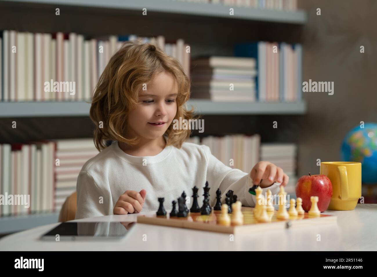 Kid playing chess in the room. Child playing chess. Clever kid thinking ...