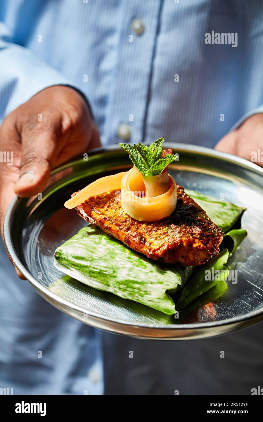 Curried fish served on a banana leaf Stock Photo - Alamy