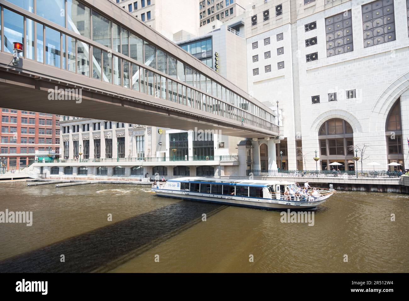 USA, Milwaukee, tourist boat passing under pedestrian bridge along the ...