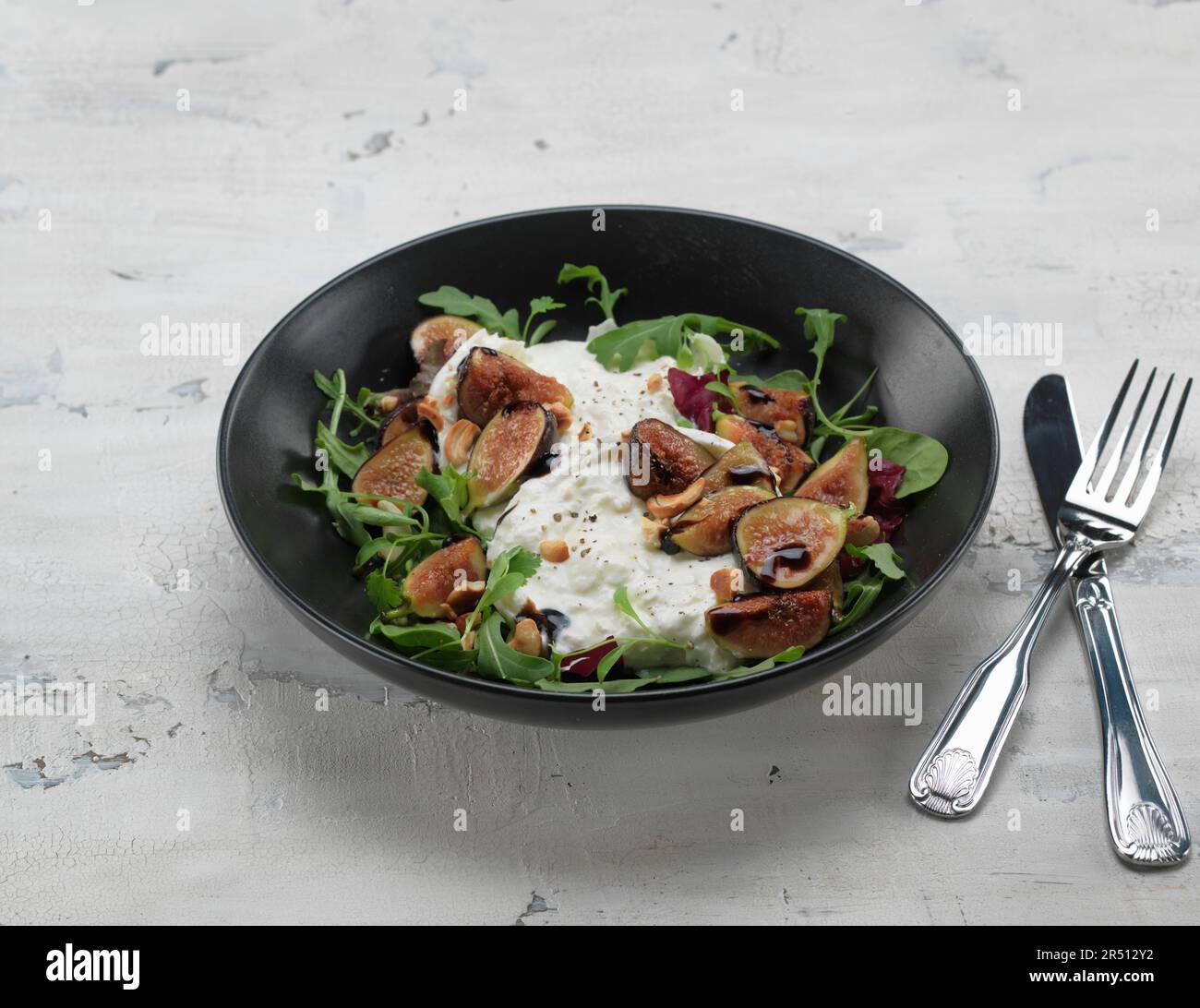 Roasted figs with burrata and rocket Stock Photo - Alamy