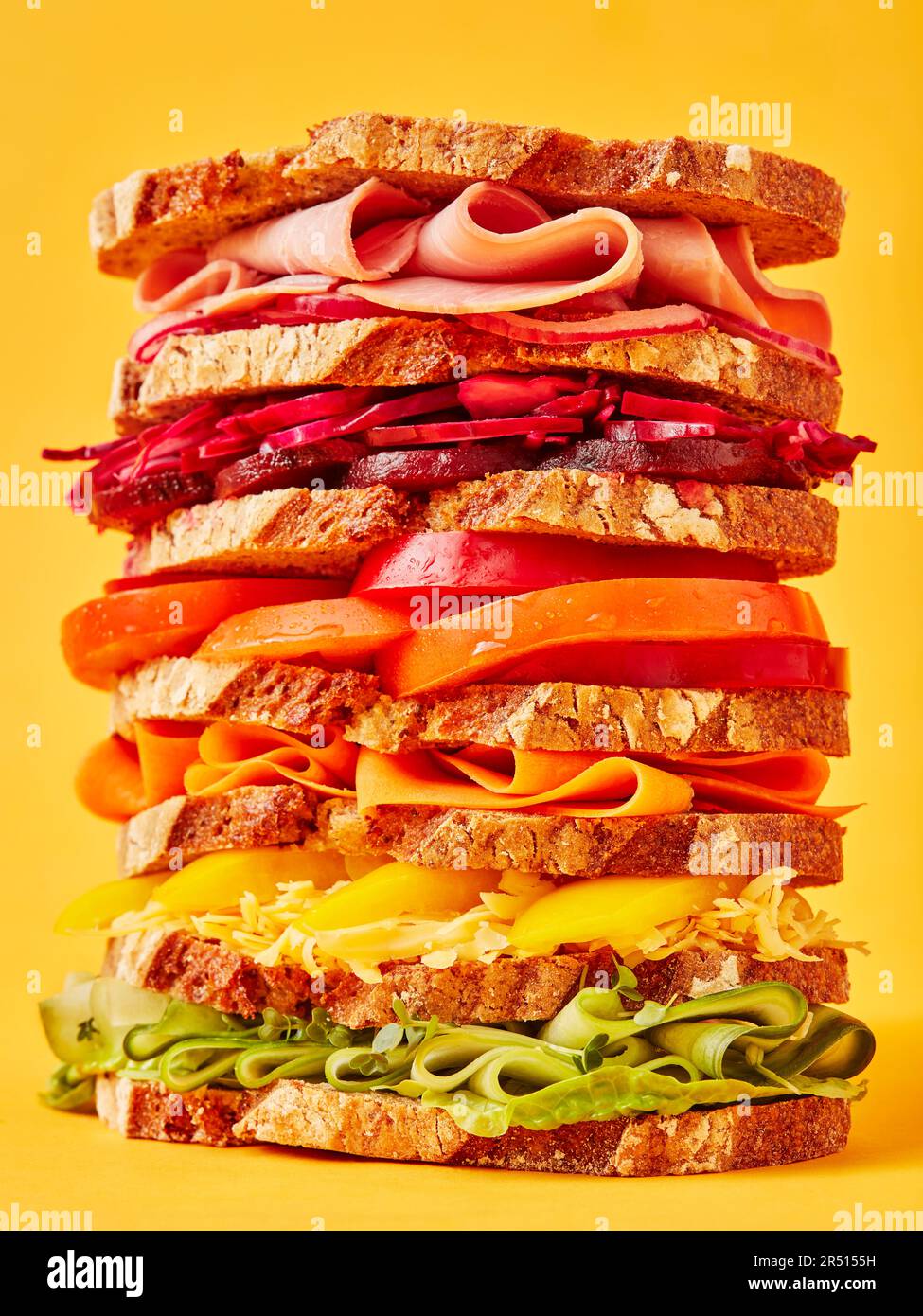 Giant rainbow sandwich against a yellow background Stock Photo - Alamy