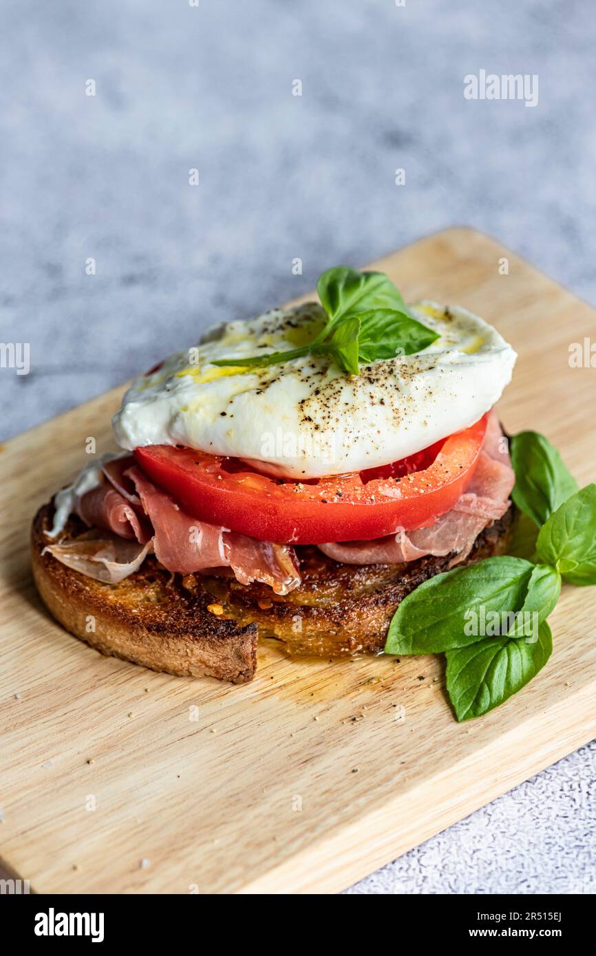 Open toasted sandwich with Serrano ham, beef tomato and burrata Stock ...