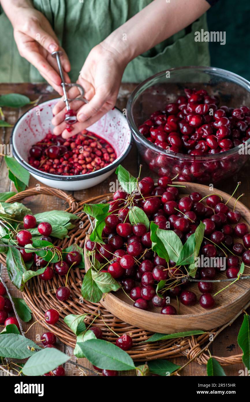 Woman pitting cherries Stock Photo - Alamy