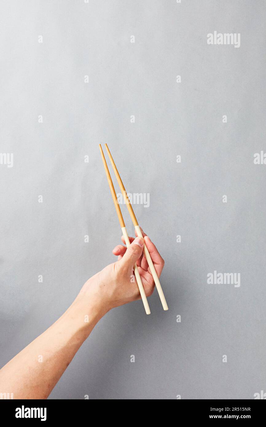 Hand holding chopsticks Stock Photo - Alamy