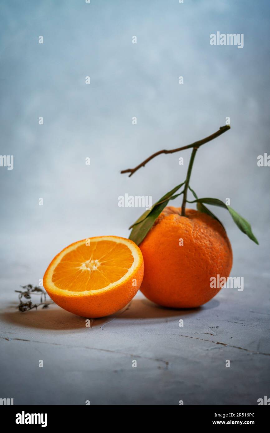 Orange halved and whole with leaves Stock Photo - Alamy
