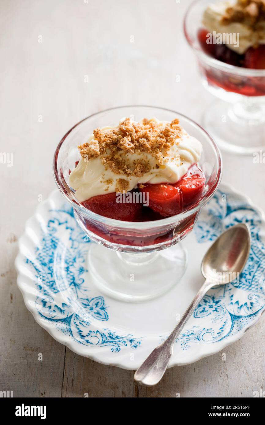 Chilled roasted plums with cream and amaretti crumble Stock Photo - Alamy