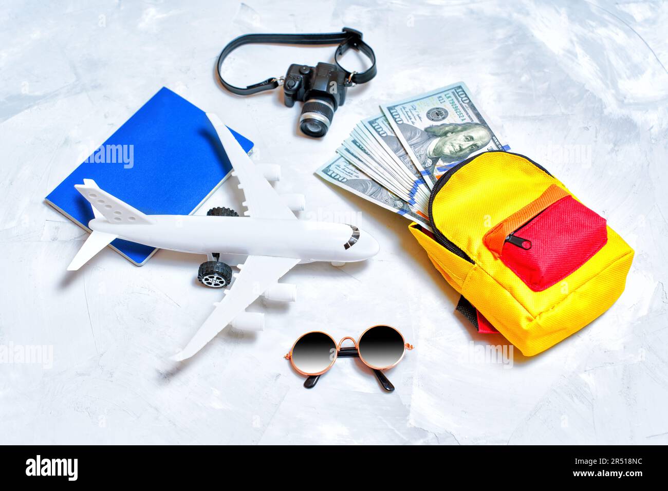 Toy airplane model, tiny backpack filled with cash, passport, miniature ...