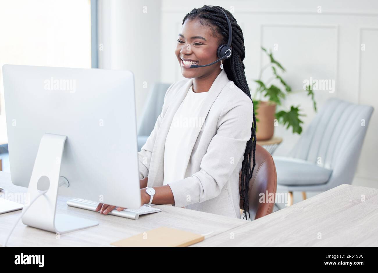 Customer service, woman with headset and computer at her desk in her ...