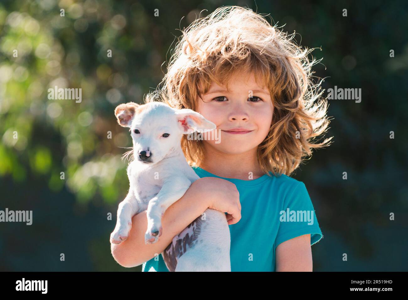 Cute kid hugging puppy dog. Child and puppy playing outside. Dog puppy ...