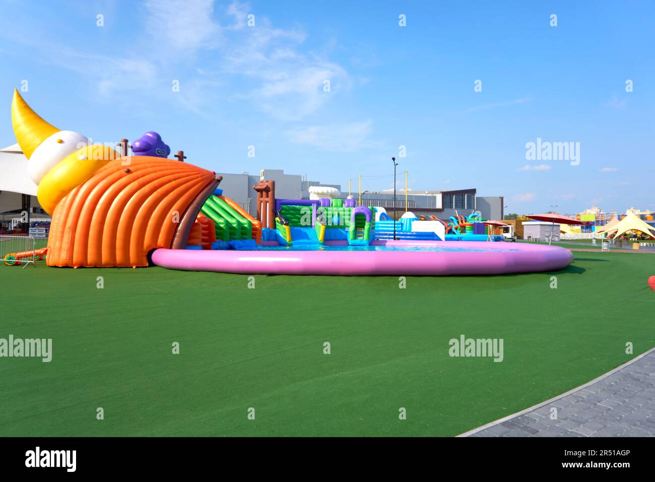 Green artificial turf lawn and swimming pool in summer spring amusement ...