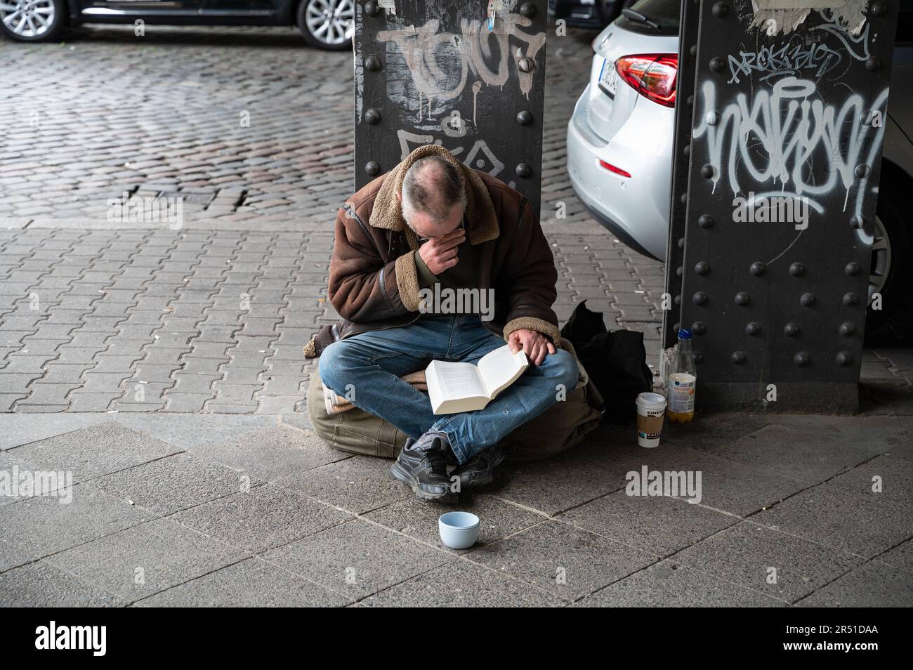 02.05.2023, Berlin, Germany, Europe - Homeless man sits under a bridge ...
