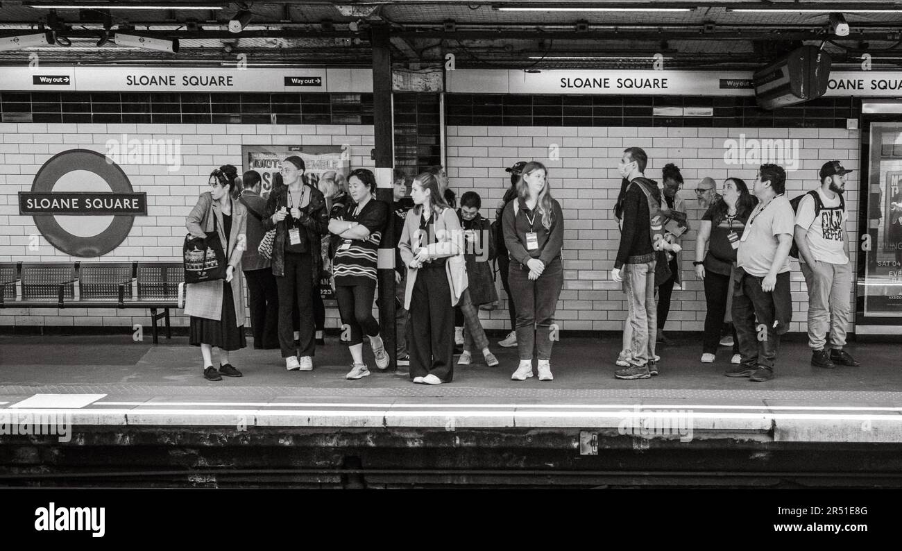 A group of people wait for for an underground train on the platform at ...
