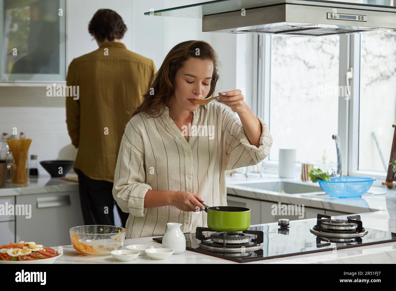 Woman tasting soup for salt when cooking dinner with husband Stock ...