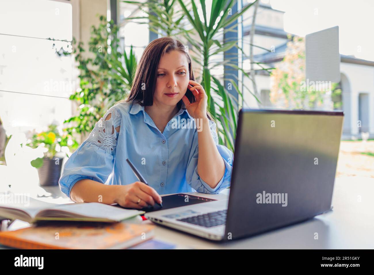 Young female teacher getting ready for lesson working in office using ...