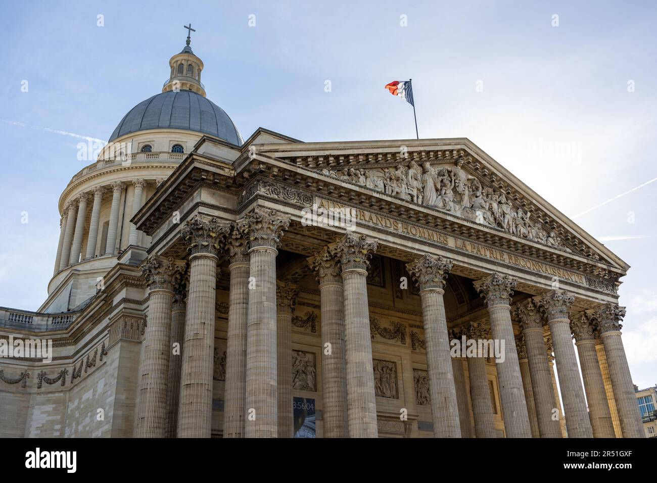 Pantheon building in Paris, France with focus on French flag over blue ...