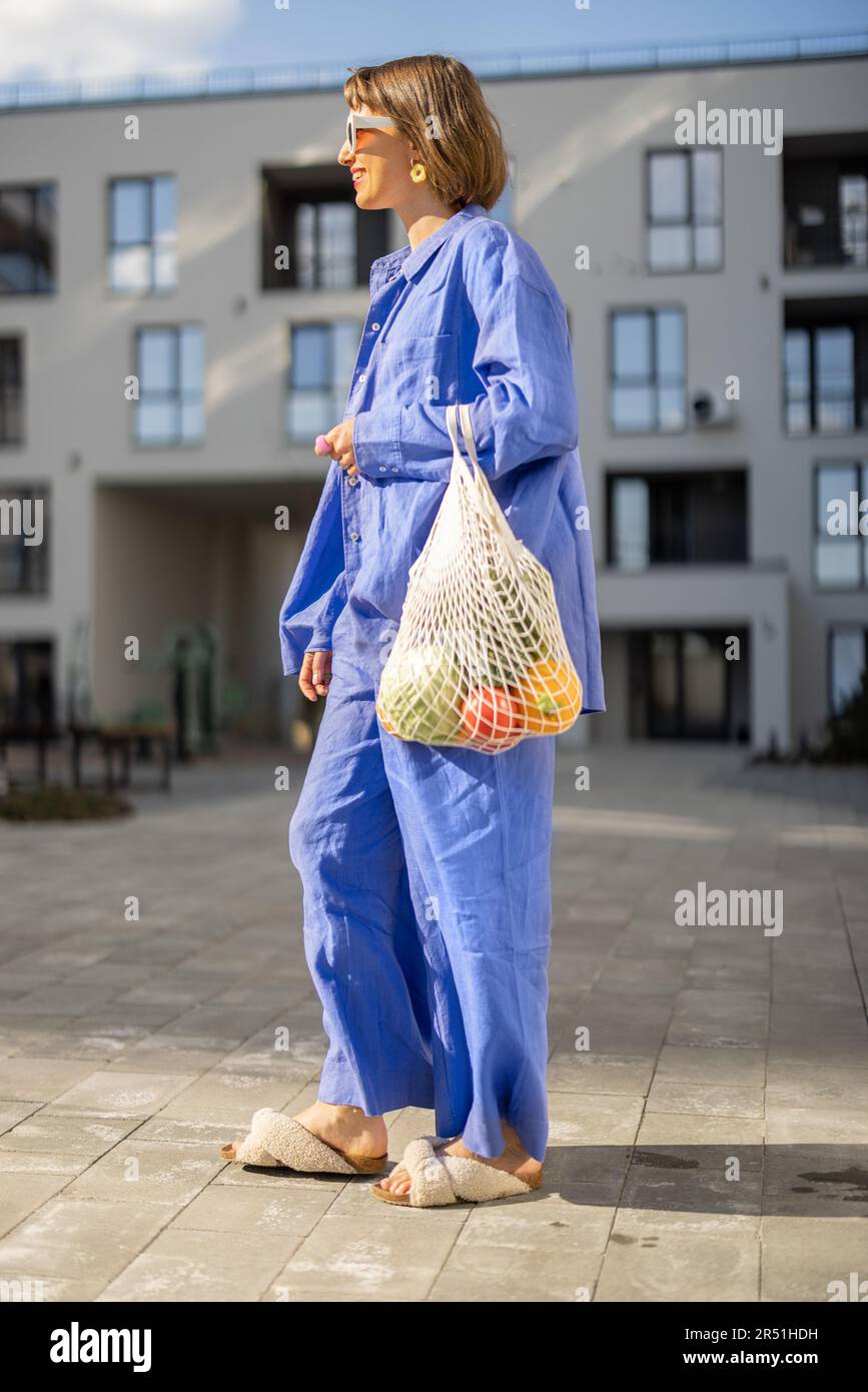 Woman carrying meshbag with fresh groceries while walking home Stock ...