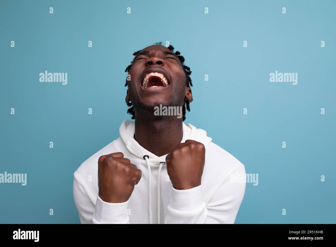 joyful winner african 20s man with dreadlocks on background with copy ...