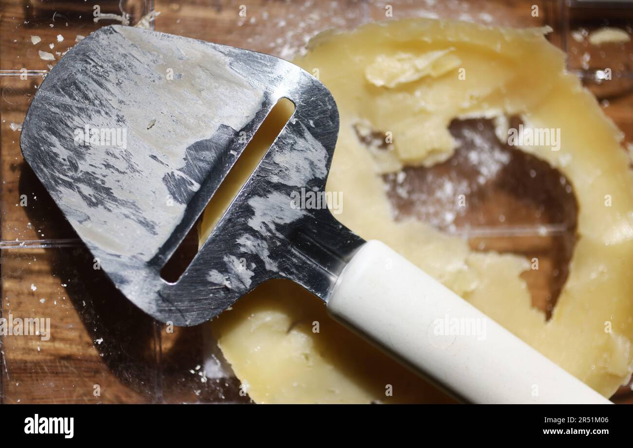 A cheese that starts to end and a cheese slicer that needs to be washed ...