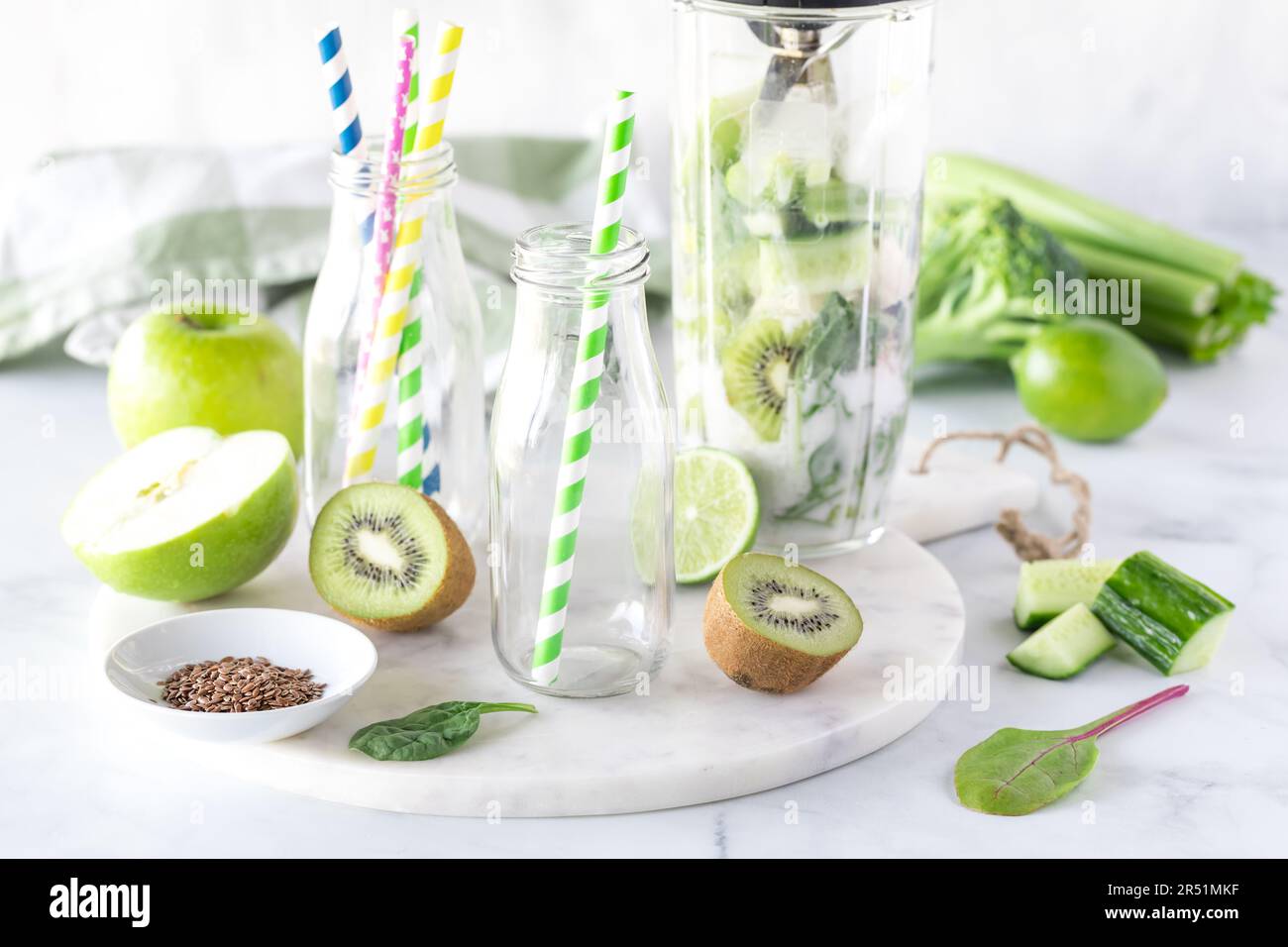A blender container filled with green ingredients to make a green ...