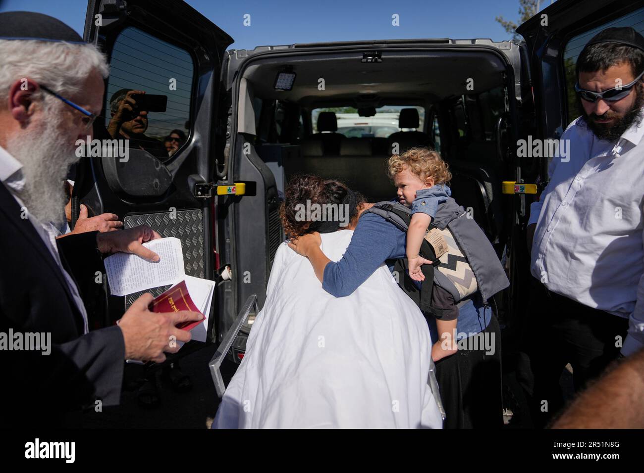 Tal Tamari carries her son as she mourns over the body of her husband ...