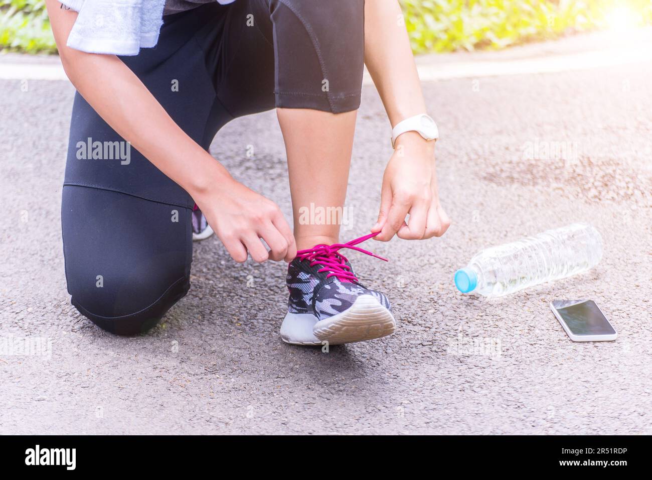 Runner woman getting ready for run tying laces of running shoes Stock ...