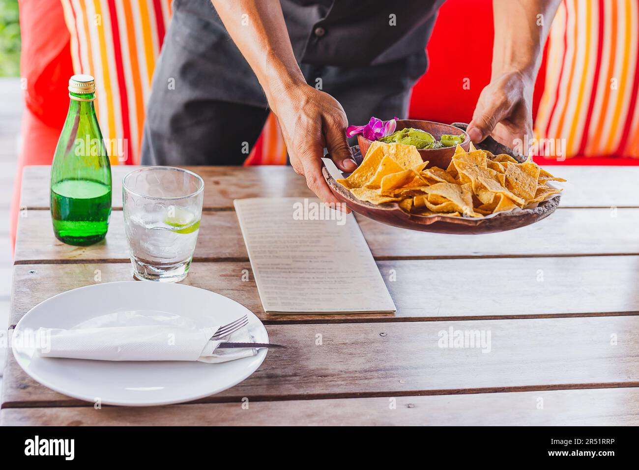Waiter serving mexican nachos chips guacamole dip Stock Photo - Alamy