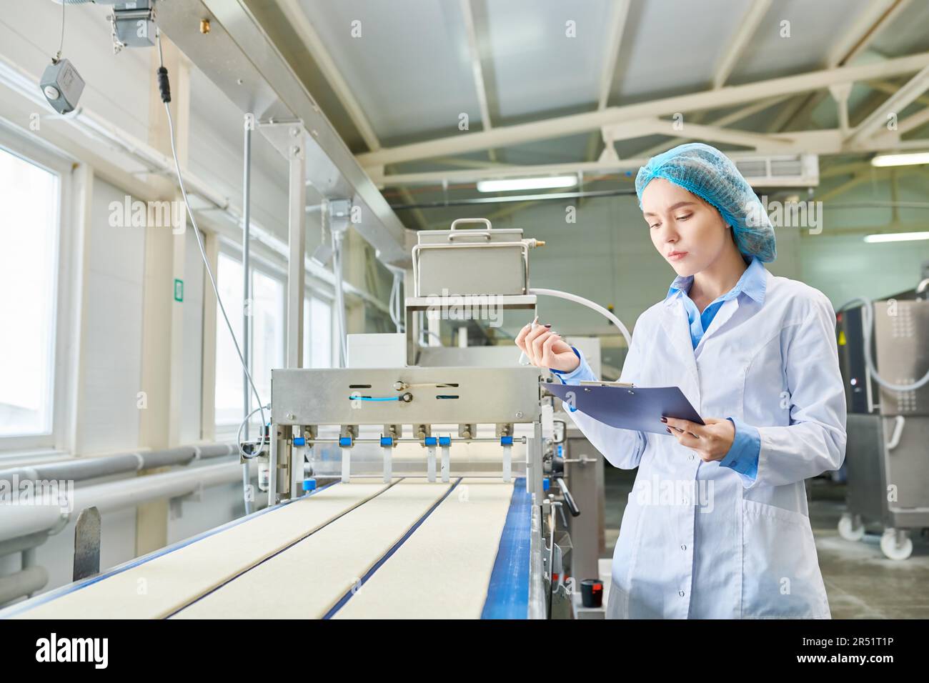 Concentrated beautiful young female food manufacturing engineer in ...