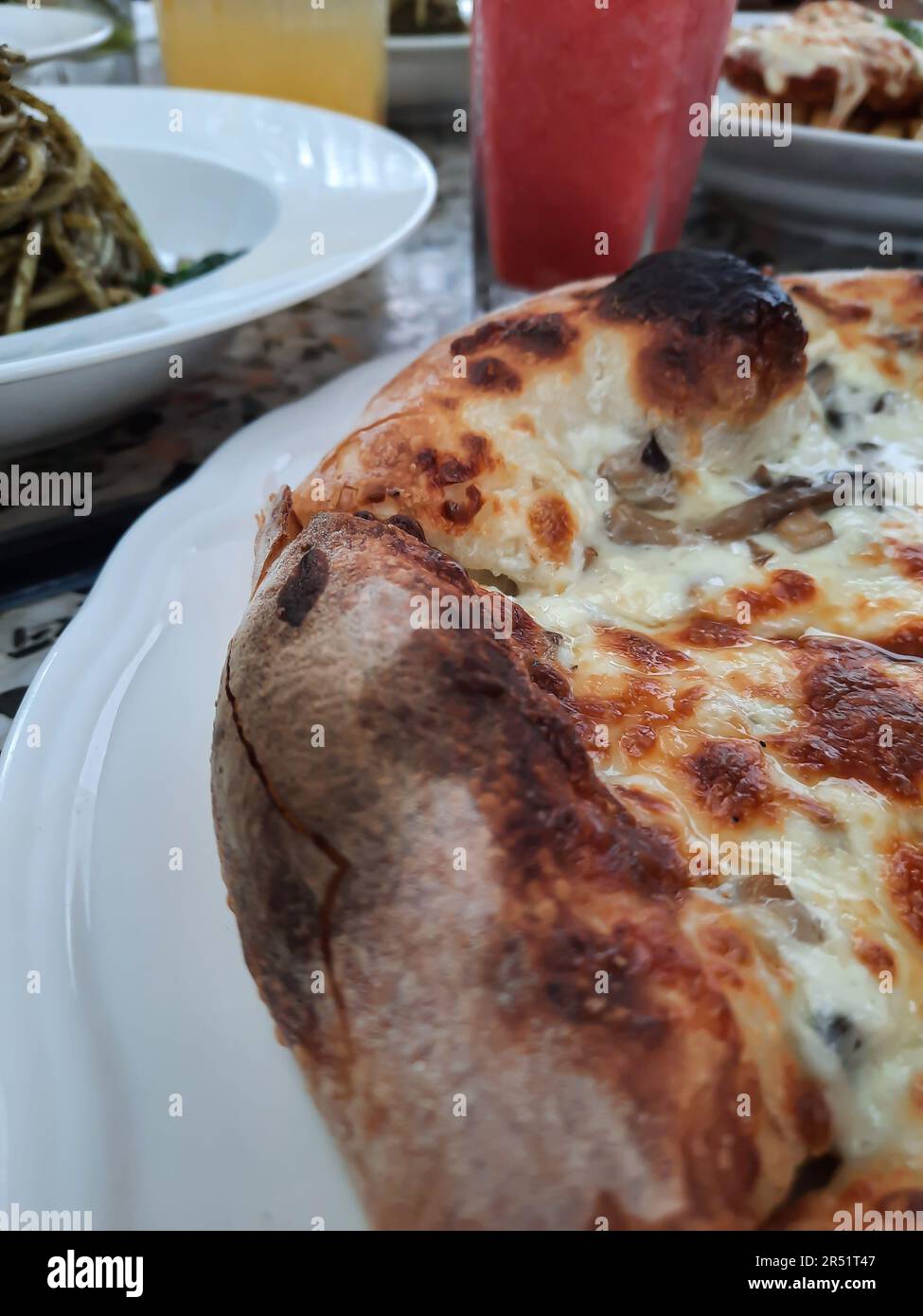 A close up look of a crunchy pizza crust with another food and juices ...