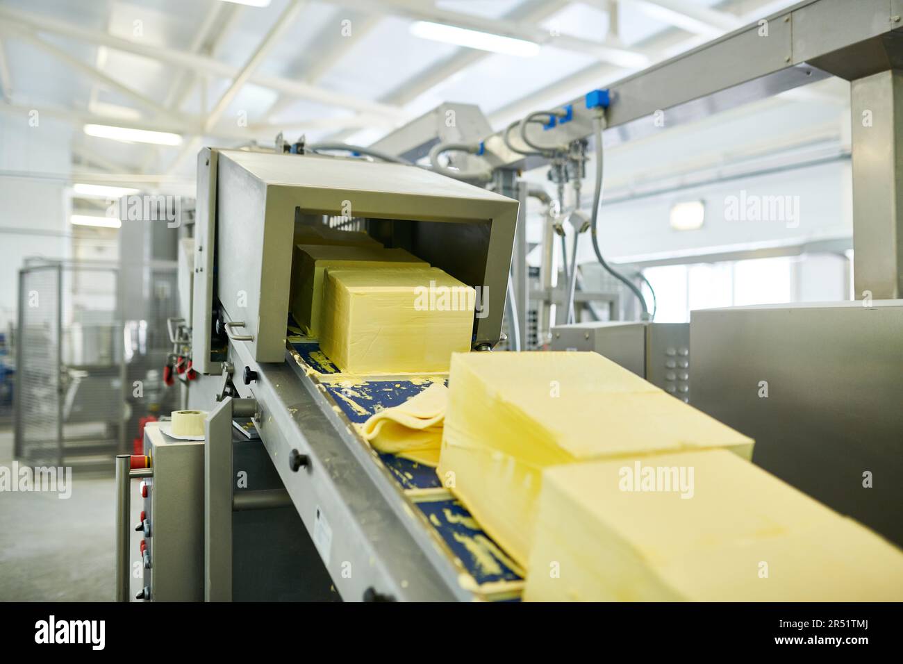 Close-up of conveyor line with butter cubes moving down for further ...