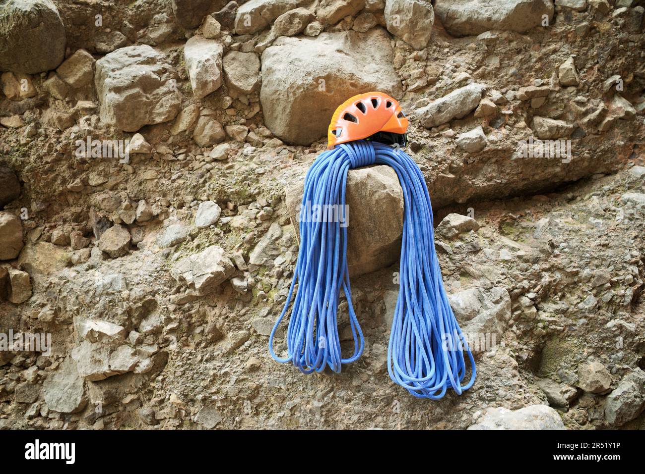 Blue climbing rope and helmet leaning against a rock face in Mallos de ...