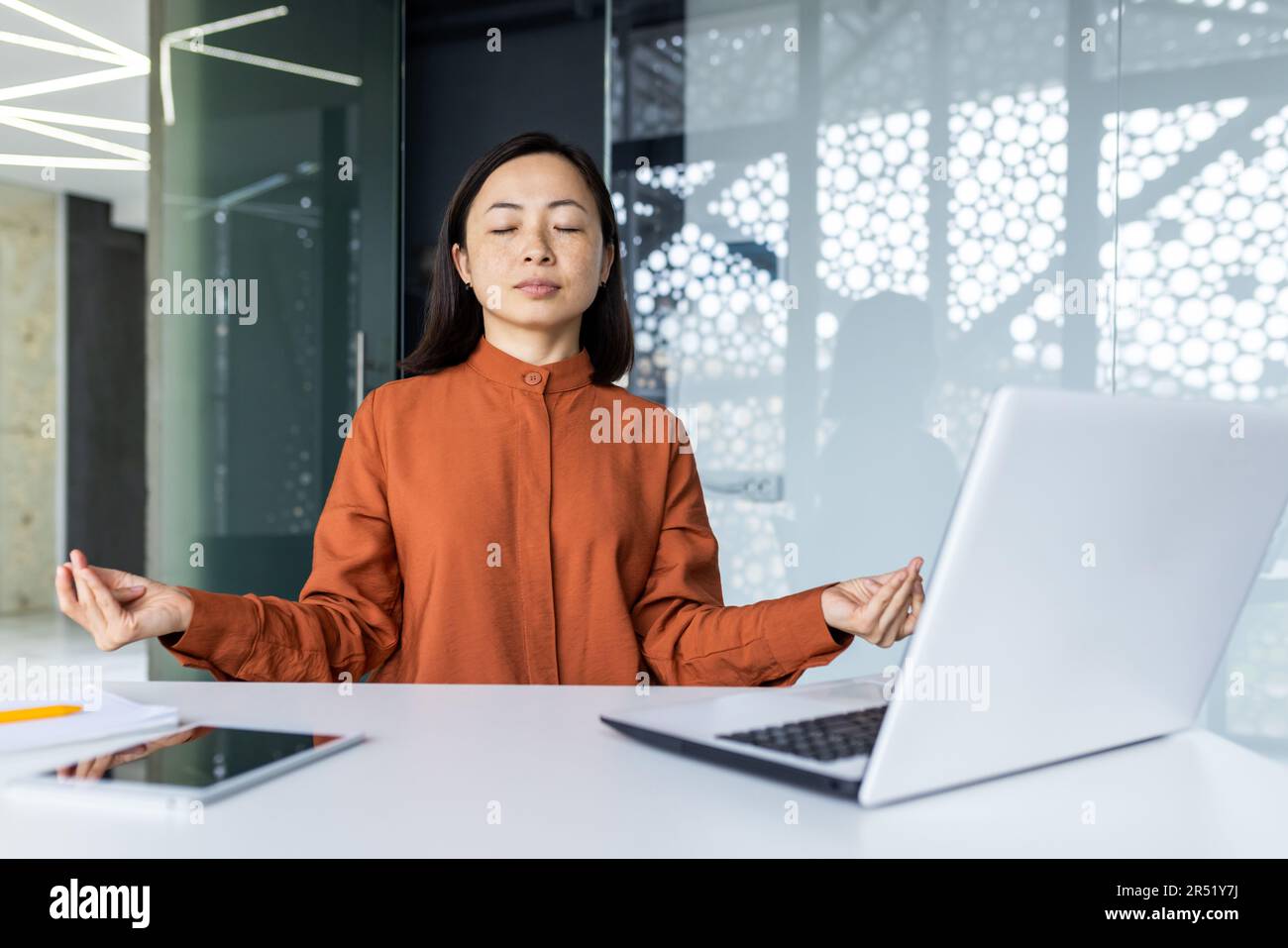Young beautiful Asian web developer working inside office building ...
