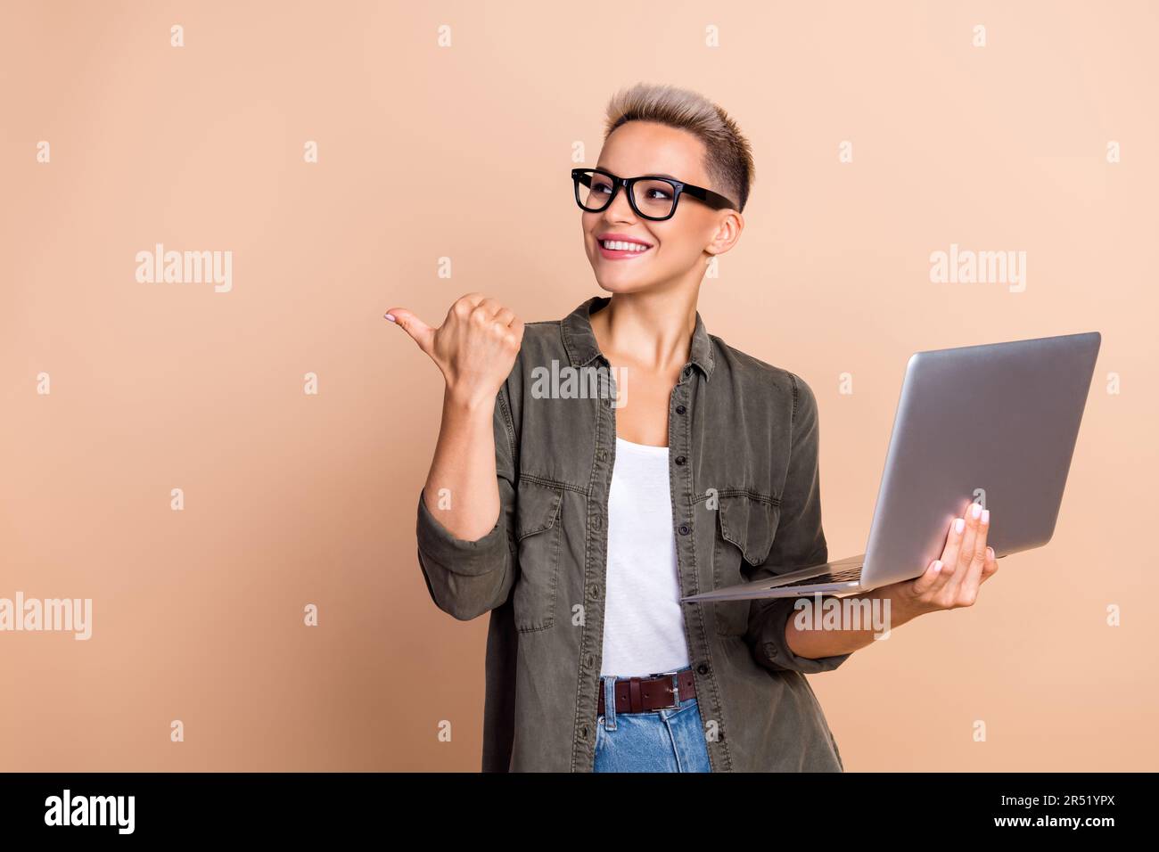 Portrait of charming lady hold netbook look indicate finger empty space ...