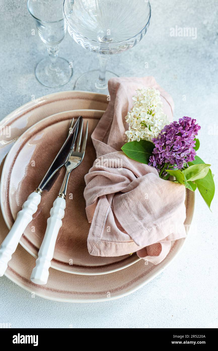 Top view of Spring table setting with lilac flowers on tableware in ...