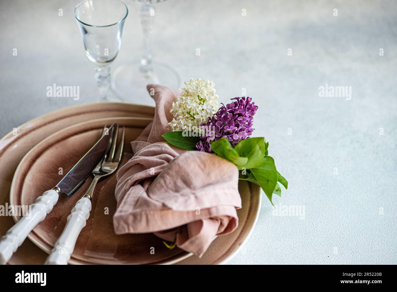 Front view of Spring table setting with lilac flowers on tableware in ...