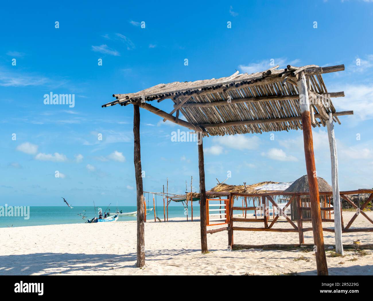 Thatched palapa shade shelters on sandy beach with blue calm sea, Gulf ...
