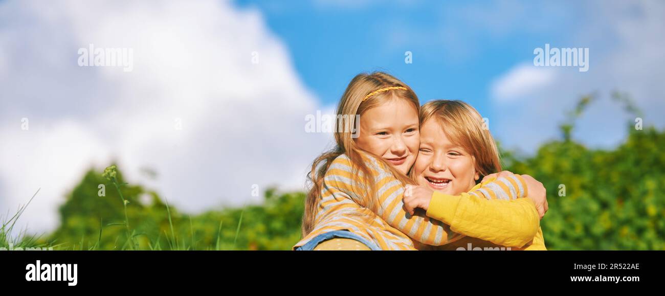 Banner with 2 funny children hugging each other, playing together ...