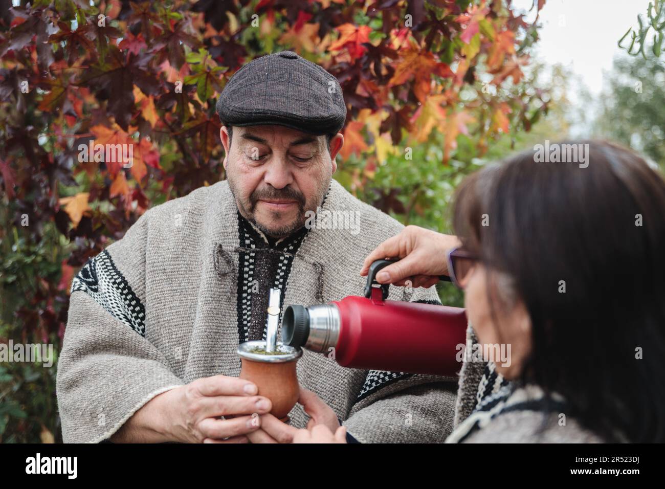 Anonymous female serving hot yerba mate to a serious male while ...