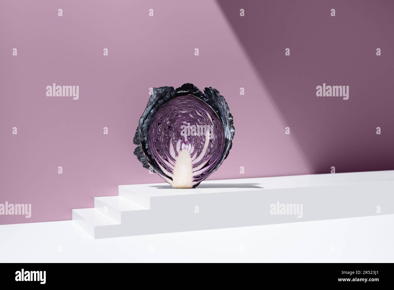 Cross section of sliced purple cabbage placed over white stepped plain ...