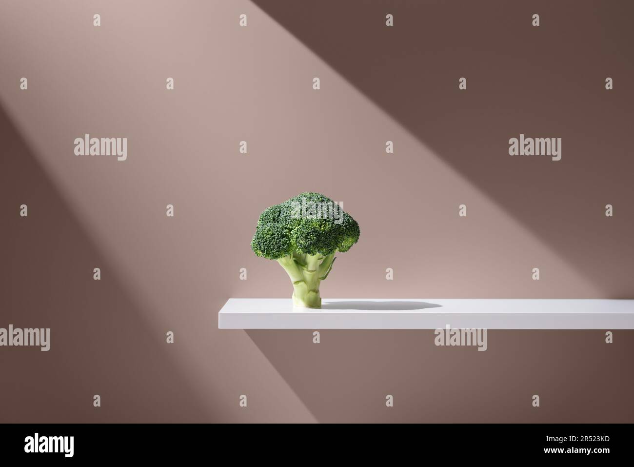Fresh bunch of broccoli with green leaves placed over white table on ...