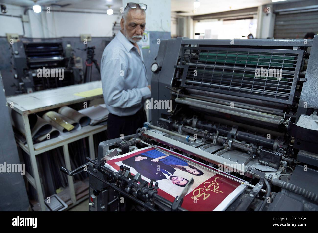 A Jordanian specialist follows the process of printing posters with ...