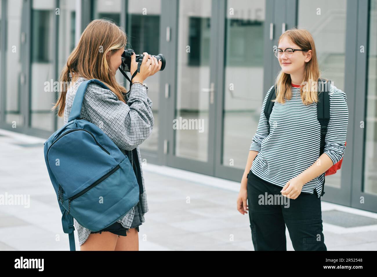 Young teenage girl taking pictures of her friend, hobby and leisure for ...