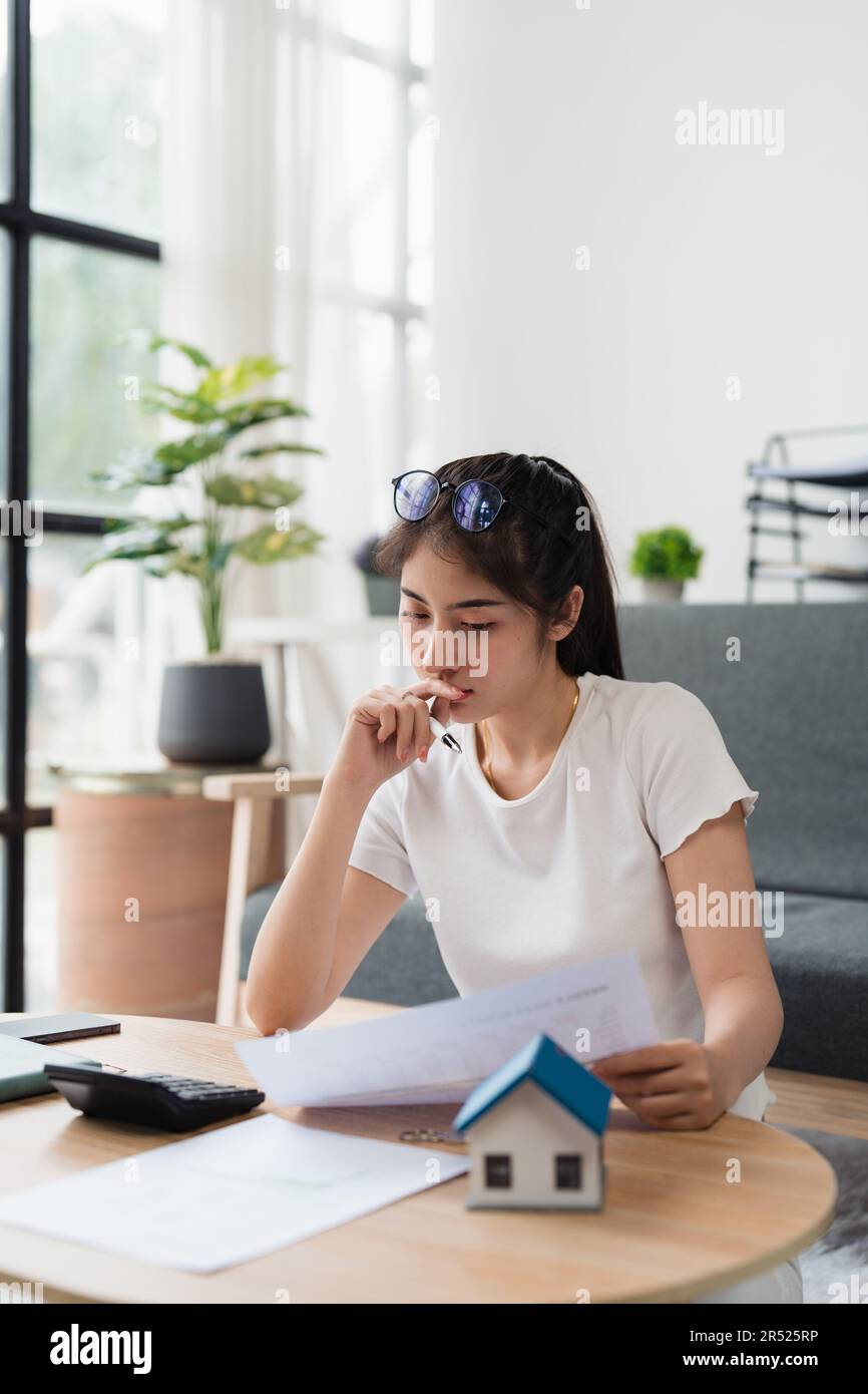 Asian accounting professional calculating household bills, reviewing ...